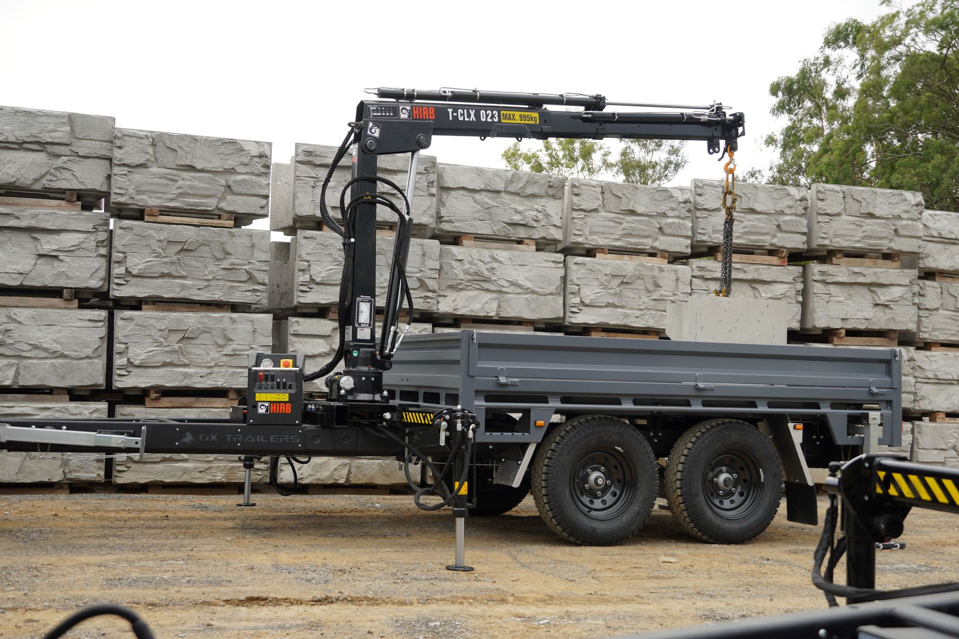 Flat Top Trailer with crane lifting concrete blocks